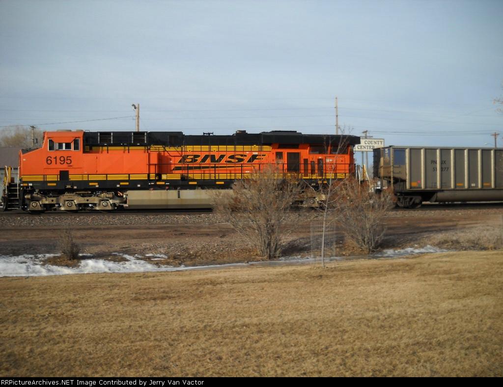 BNSF 6195 DPU on wb empties with the last of the sun downtown